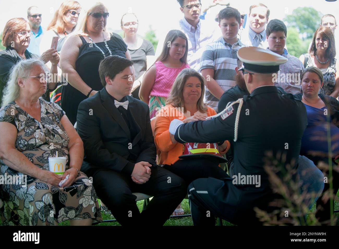 Violet Coots, center, receives an American flag from emergency medical ...