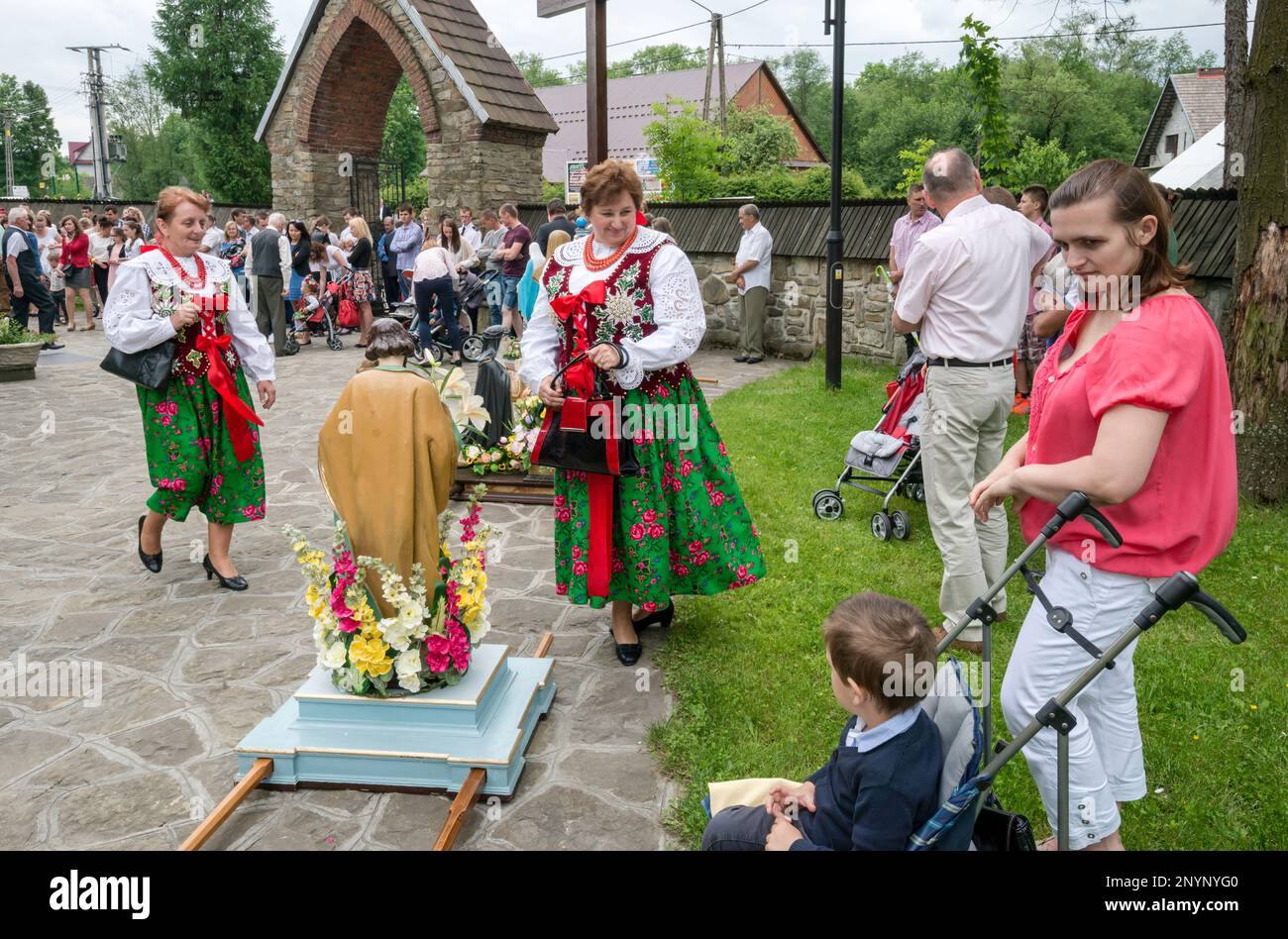 Women in traditional folk clothes, holy figures, in church courtyard ...