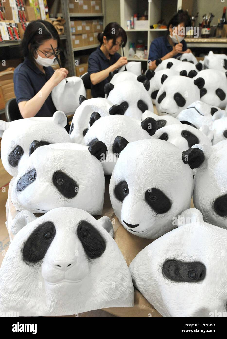 Female employees are busy making a giant panda's rubber face at Ogawa ...
