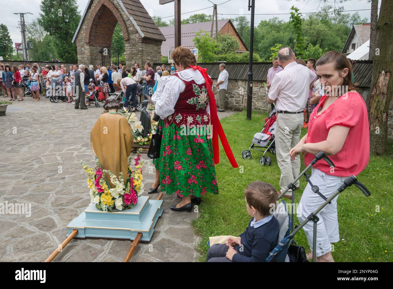 Women in traditional folk clothes, holy figures, in church courtyard ...