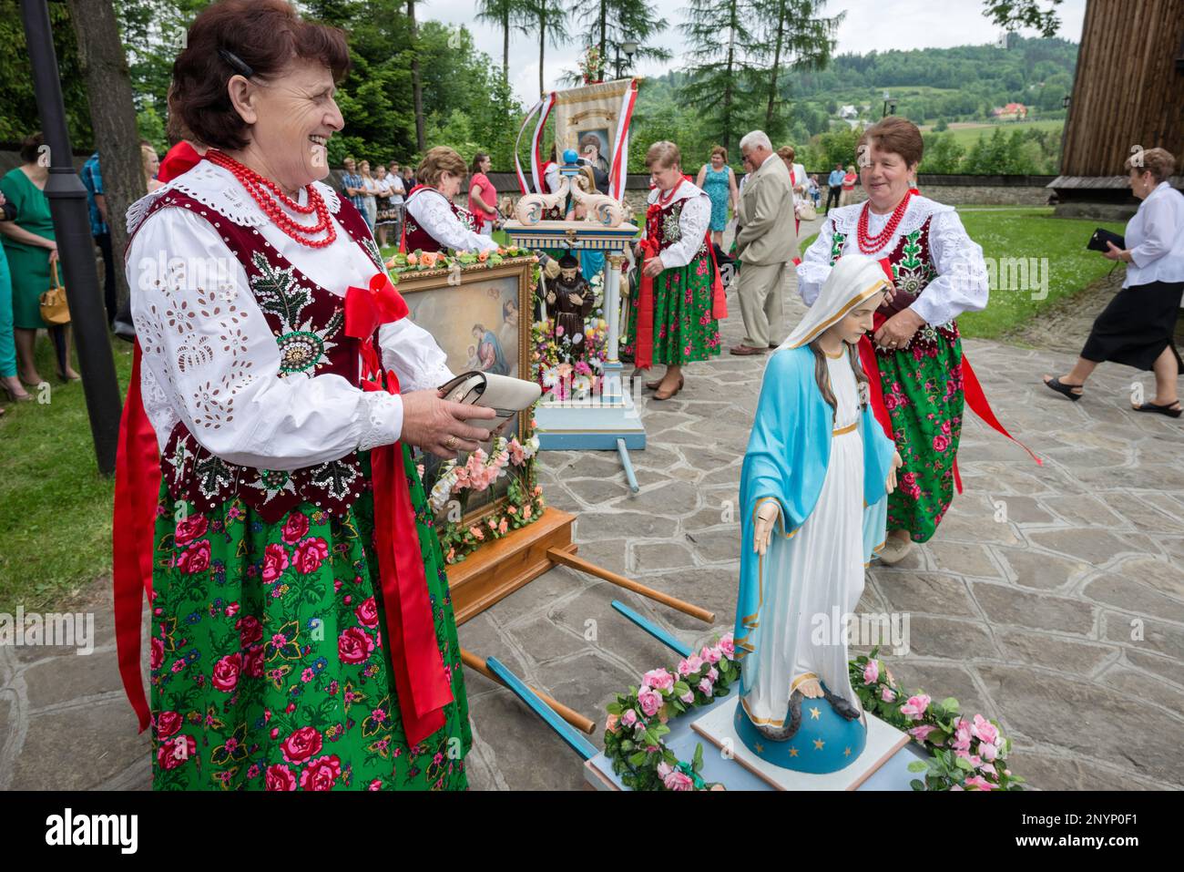 Women in traditional folk clothes, holy figures and paintings, in ...