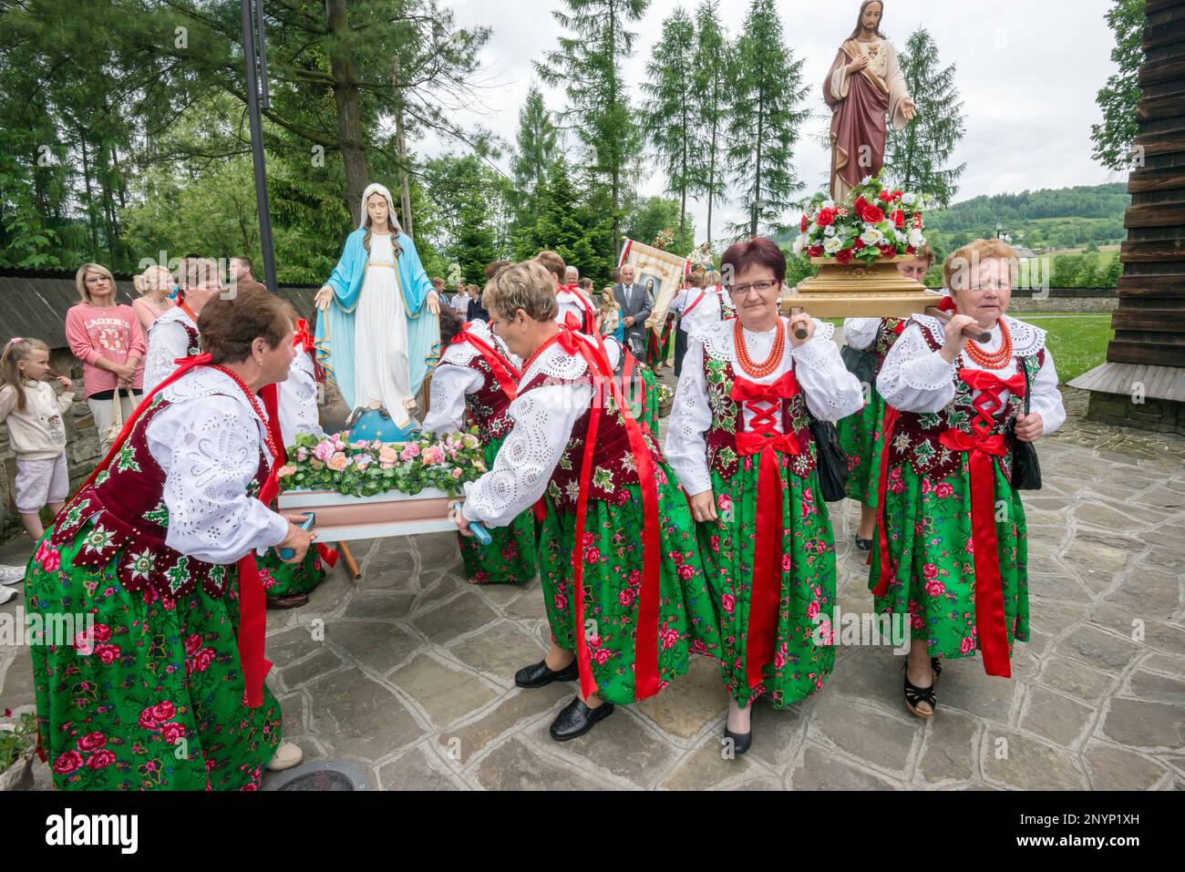 Women in traditional folk clothes, carrying holy figures, in church ...