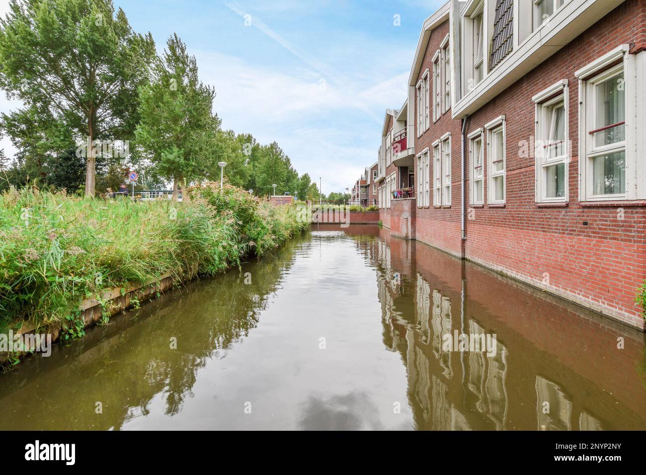 a canal in the middle of an urban area with buildings and trees on ...