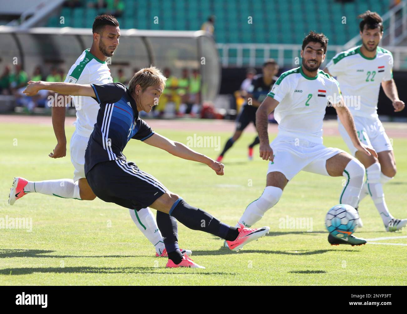 Japan's forward Genki Haraguchi (front) drives a ball in the first half ...