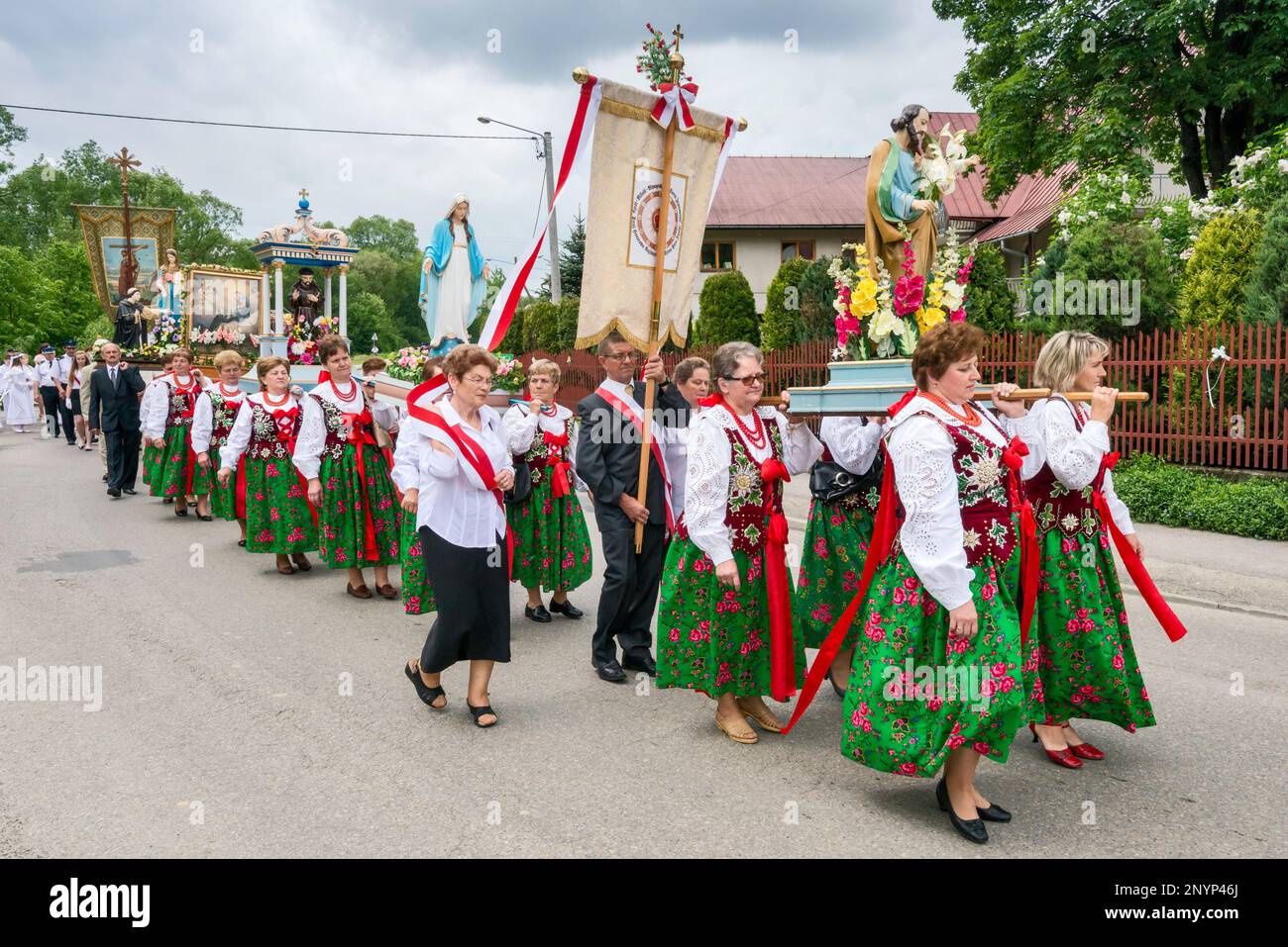 Women in traditional folk clothes, carrying holy figures and paintings ...