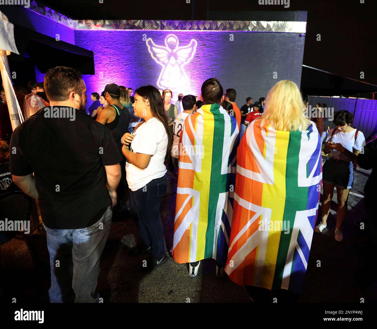 Visitors from London don rainbow-colored flags of Union Jack during a ...
