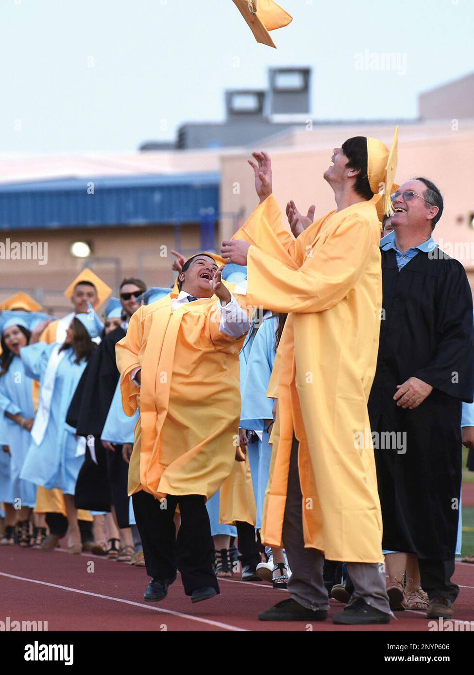 An excited graduating senior tosses his cap while walking down the ...