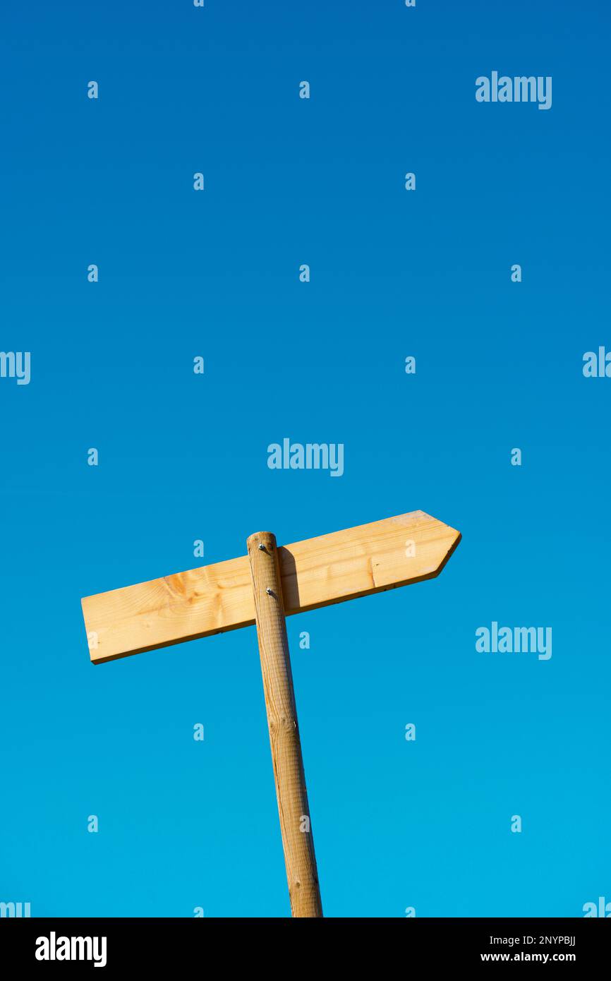 Wooden arrow on a pole indicating direction and clear blue sky Stock ...
