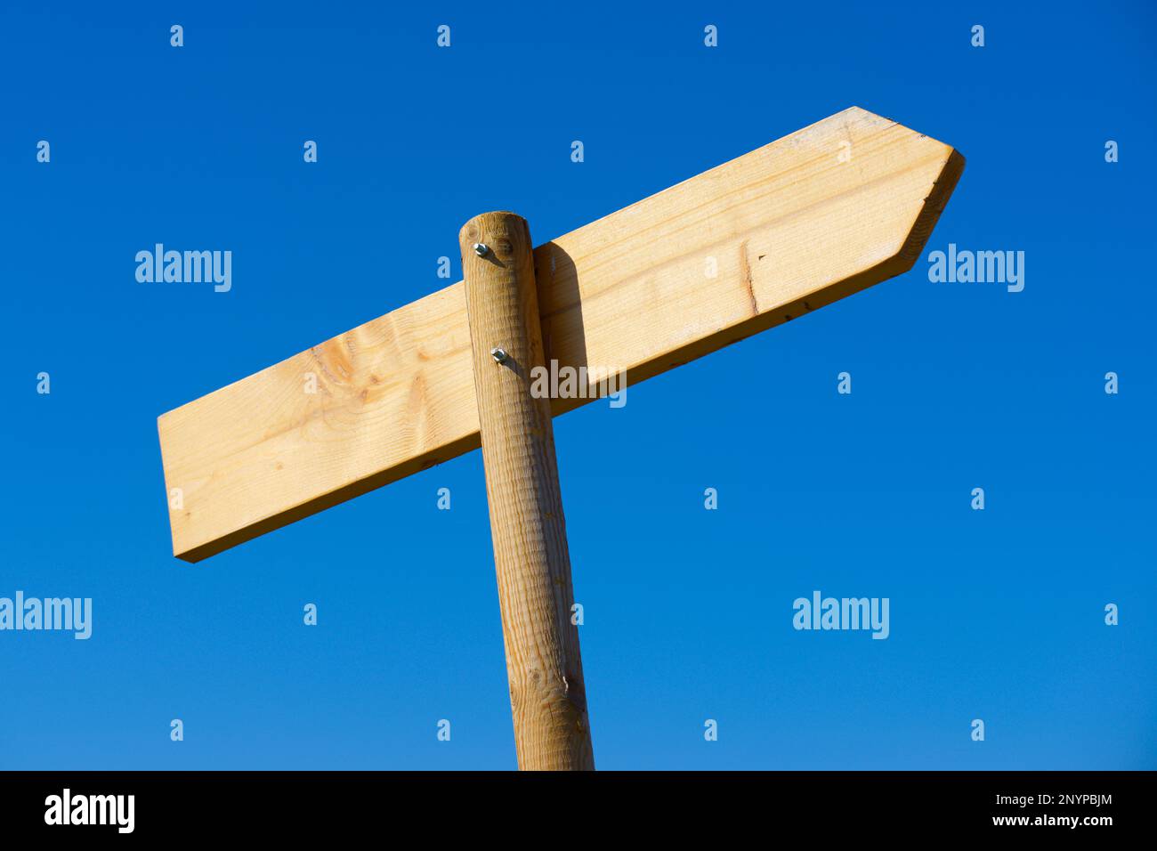 Wooden arrow on a pole indicating direction and clear blue sky Stock ...