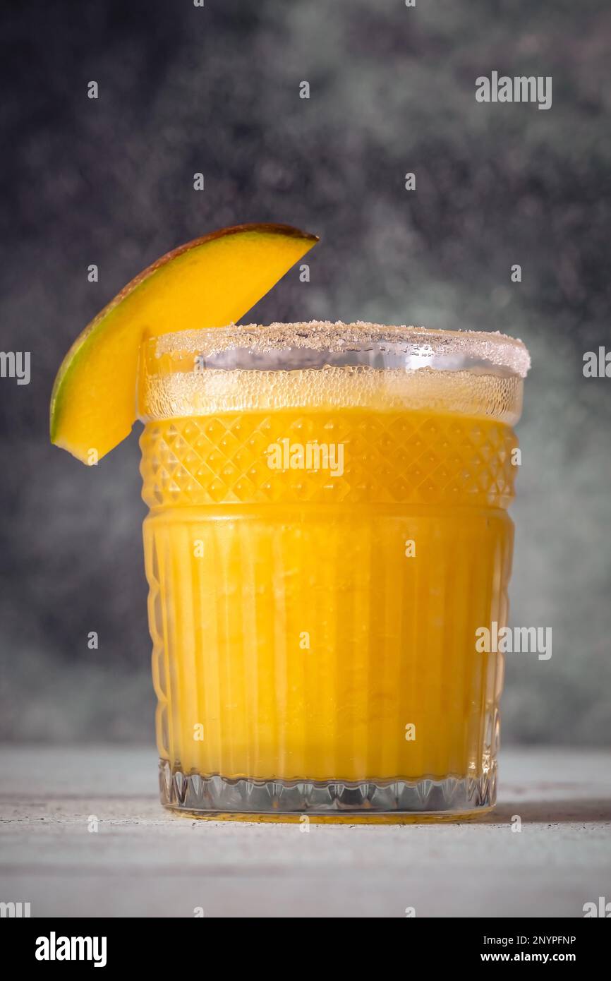 Glass of Frozen Mango Margarita cocktail garnished with mango slice ...