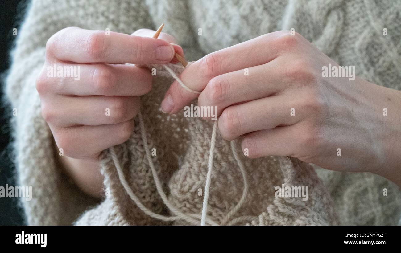 Female hands knitting in cose-up. Girl relaxing knitting a warm sweater ...
