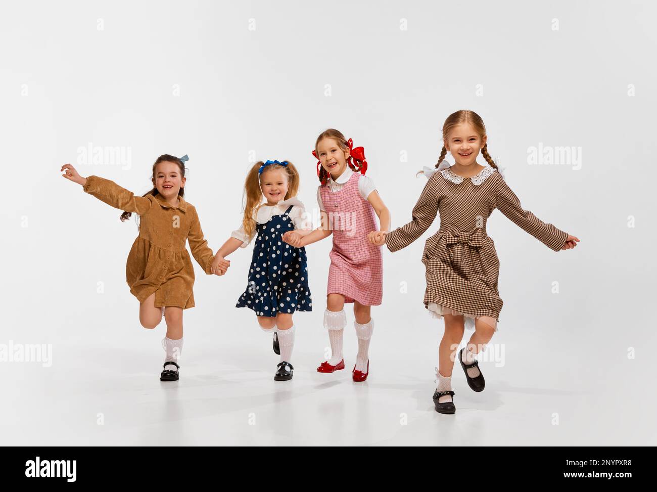 Four beautiful little girls, kids in stylish retro dresses posing ...