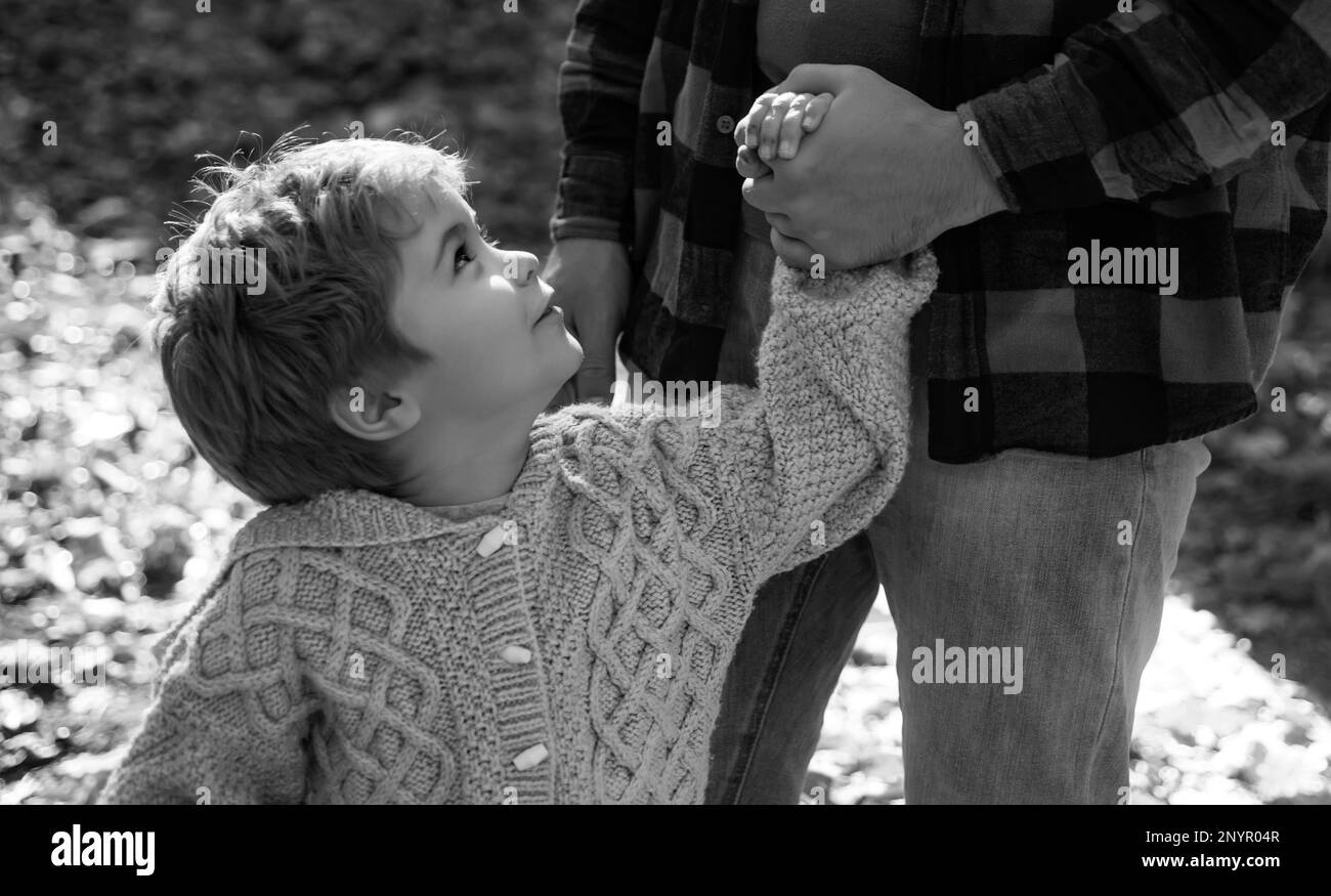 Father and son walking together in the park, fall day. Kid and his ...
