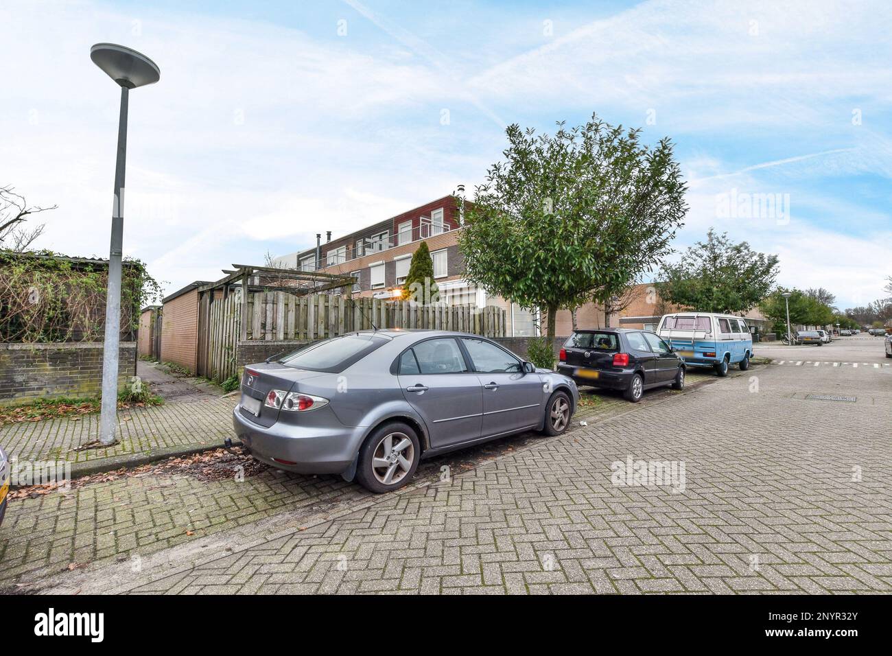 some cars parked on the side of the road in front of a bricked building ...