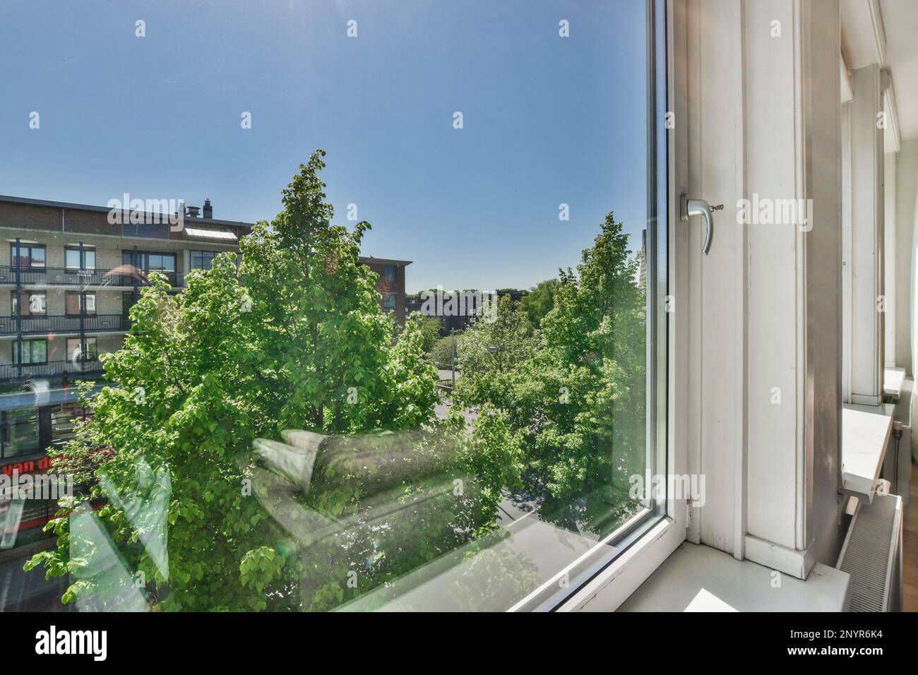 an outside area with trees and buildings seen through the window ...