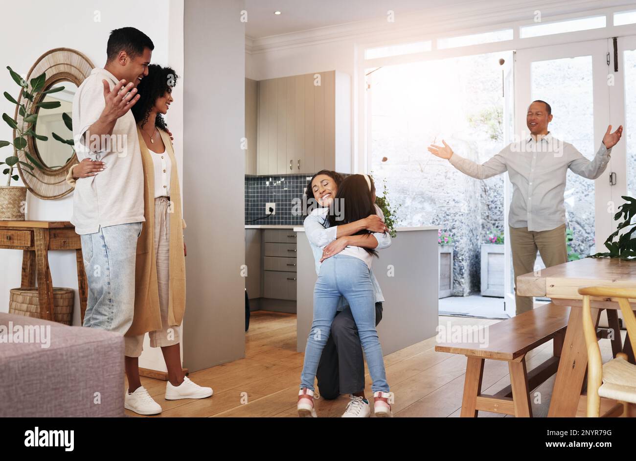 Welcome, happy and hug with grandparents and family in living room for ...