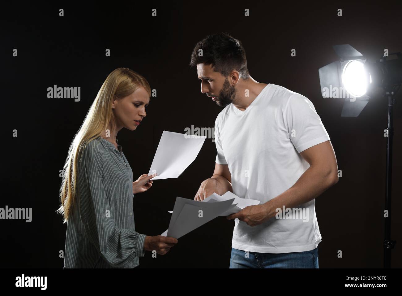 Professional actors reading their scripts during rehearsal in theatre ...