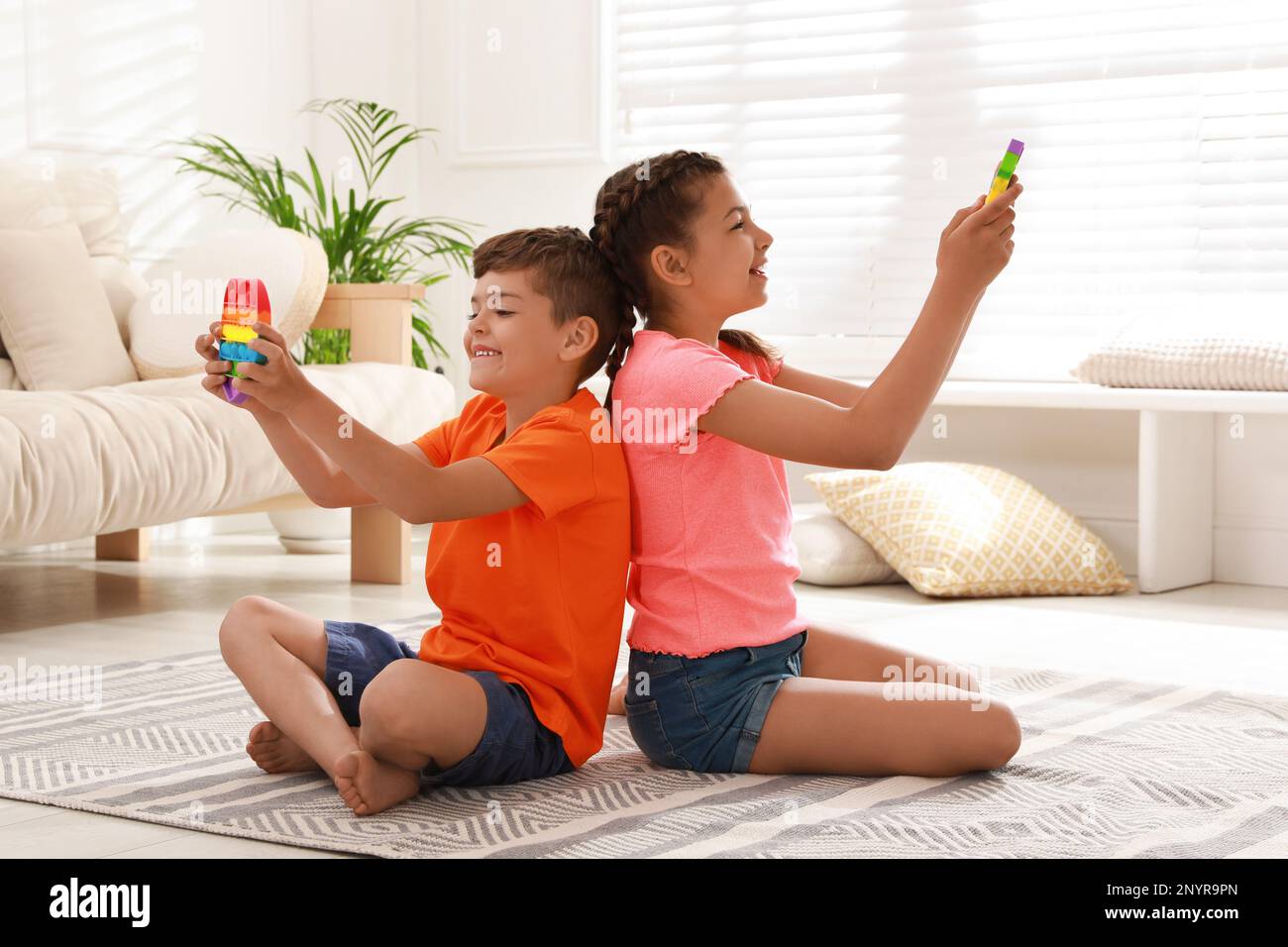 Children playing with pop it fidget toys on floor at home Stock Photo ...