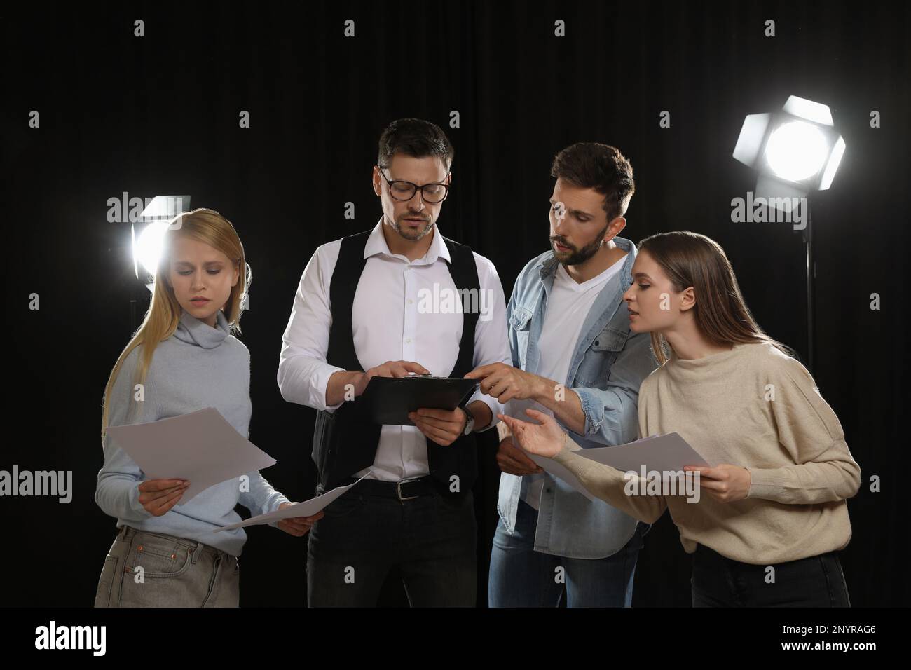 Professional actors reading their scripts during rehearsal in theatre ...