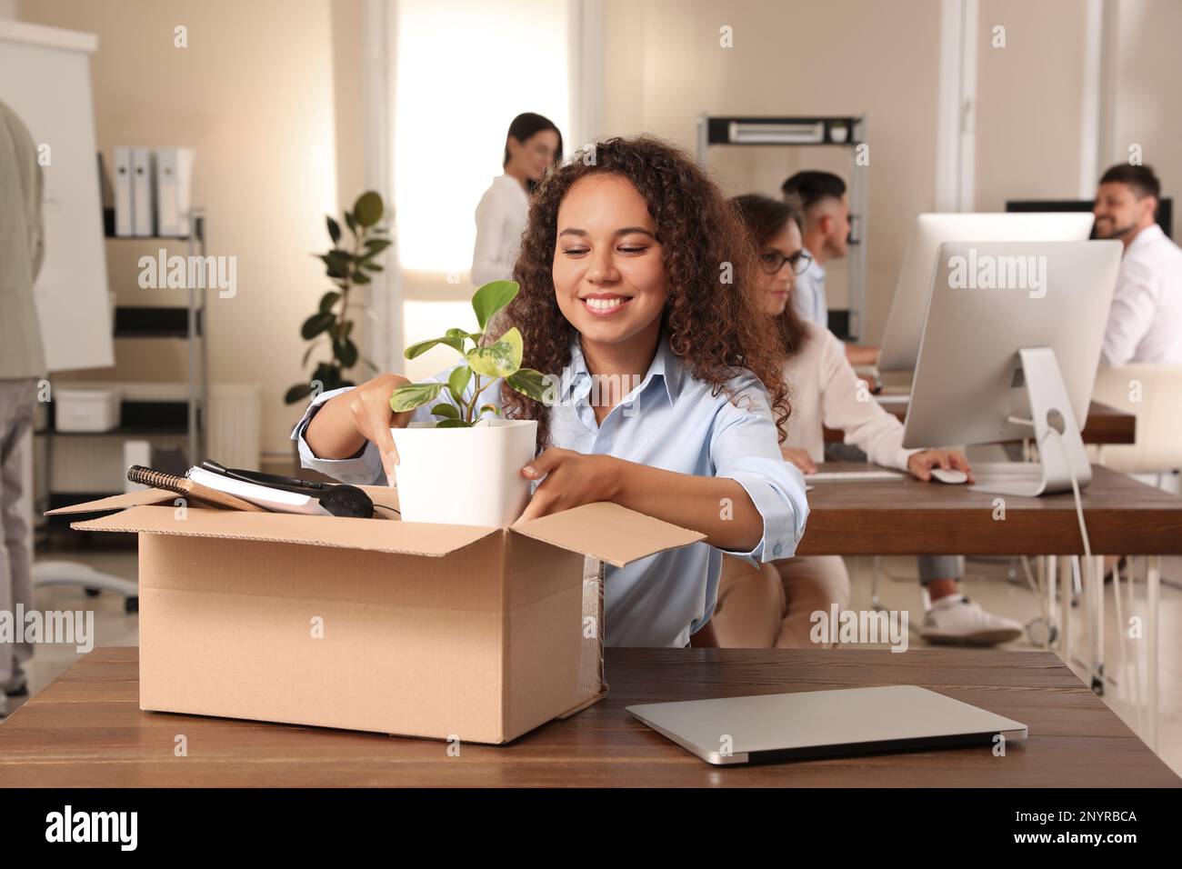 New coworker unpacking box with personal items at workplace in office ...