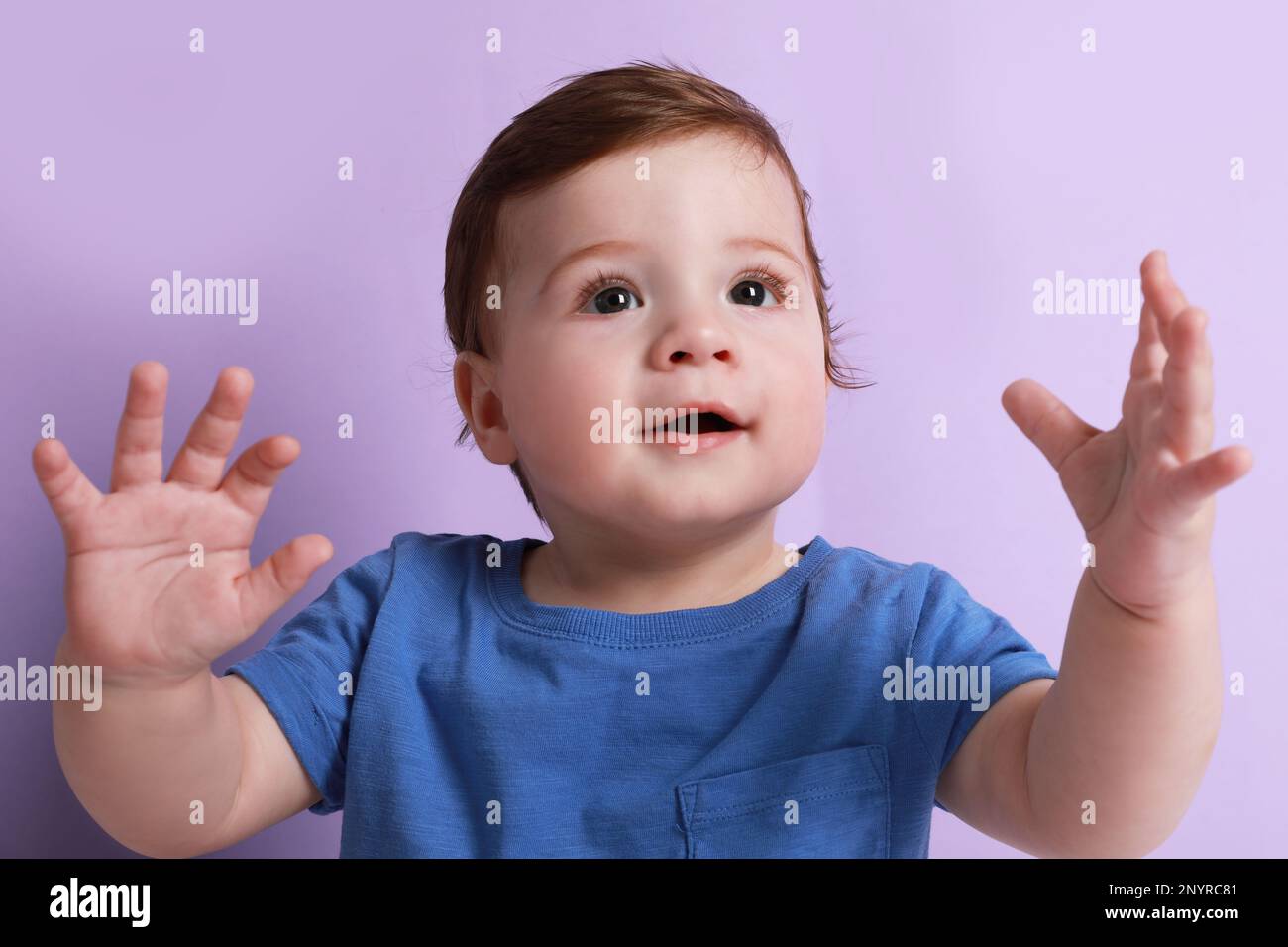 Cute little baby boy on violet background Stock Photo - Alamy