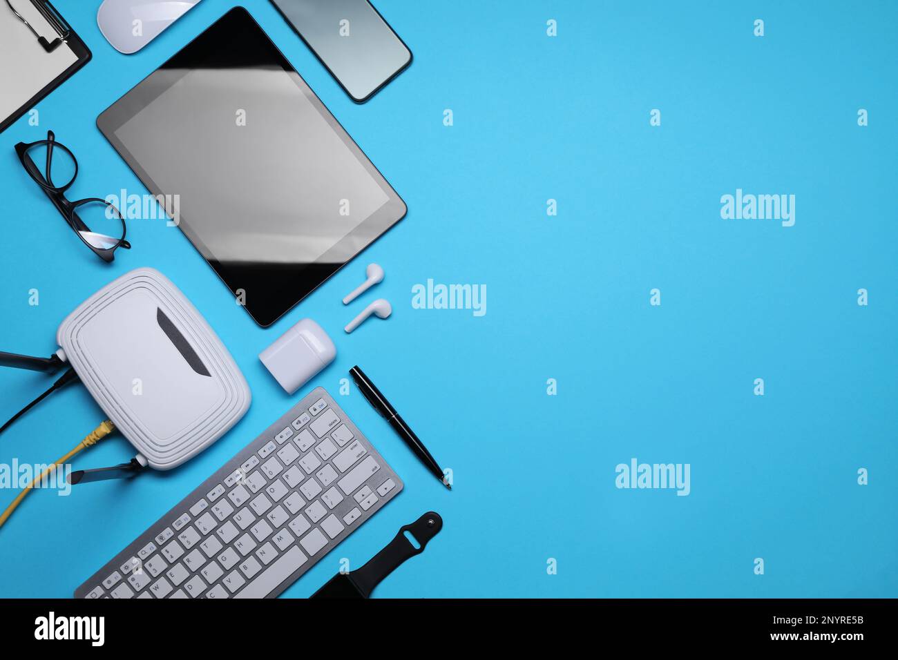 Flat lay composition with modern Wi-Fi router on light blue background ...