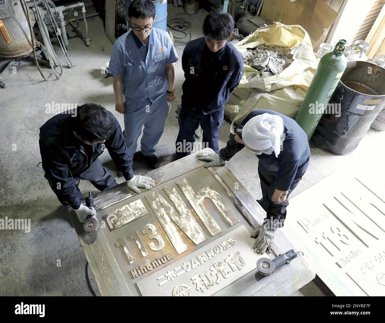 Workers manufacture a bronze plate to celebrate the naming of new ...
