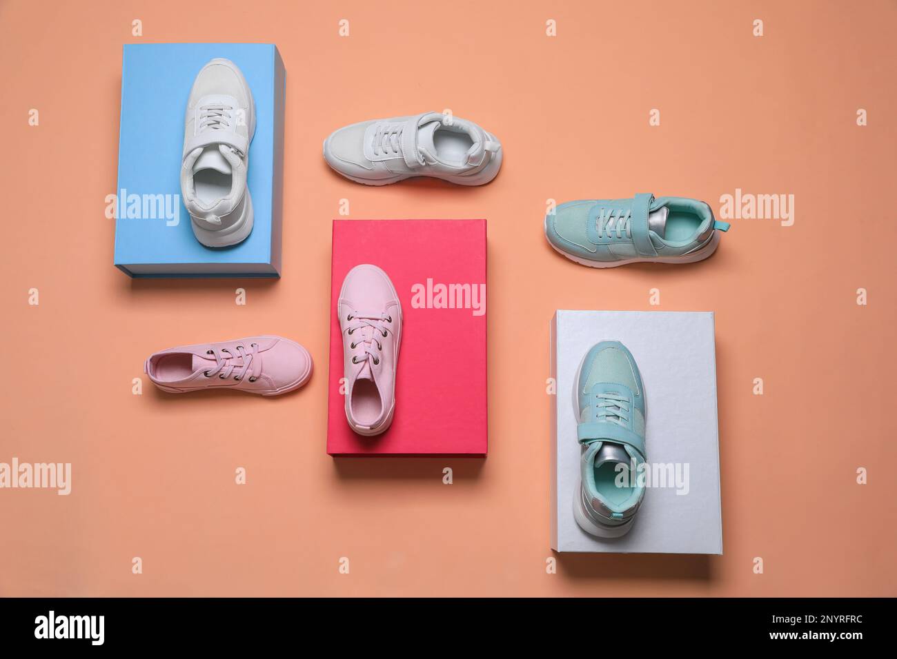 Flat lay composition with different stylish sports shoes on pale coral ...