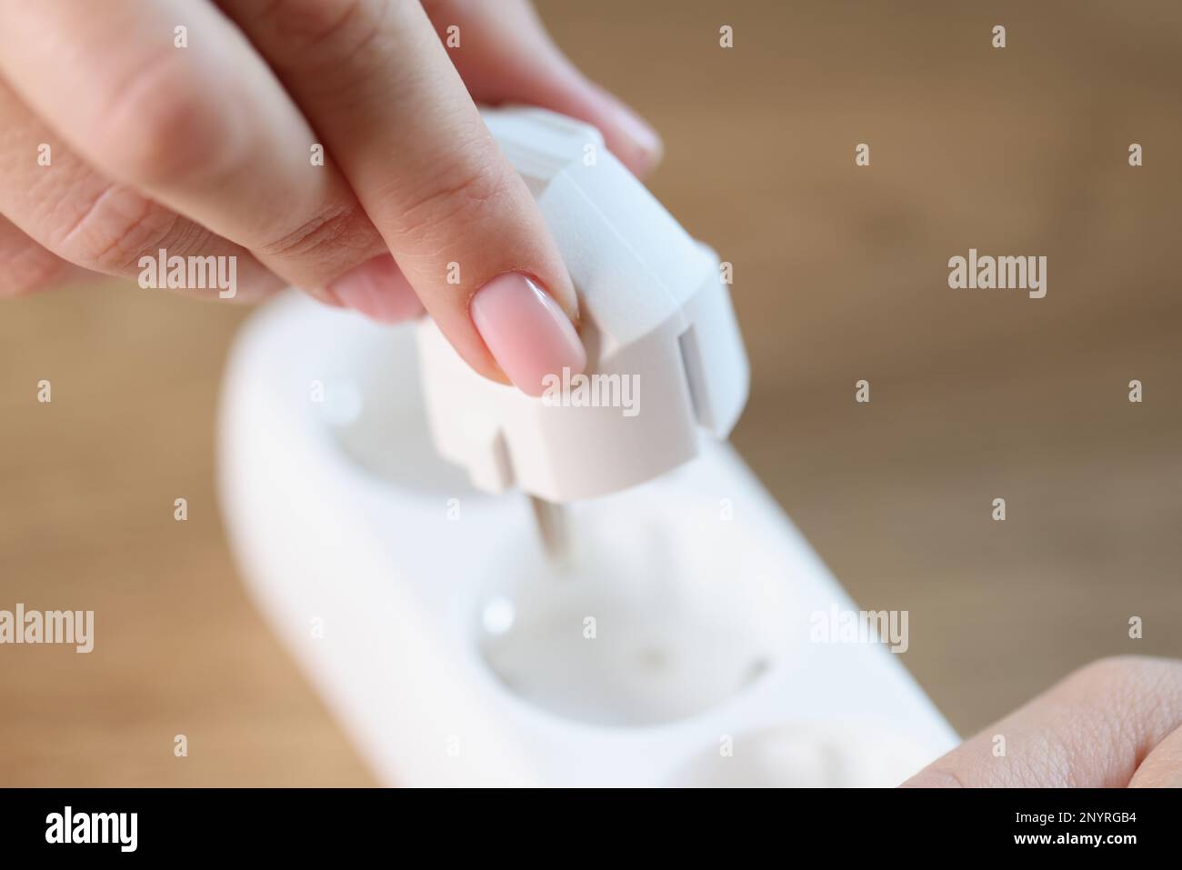Female hand inserting electric plug into white socket Stock Photo - Alamy