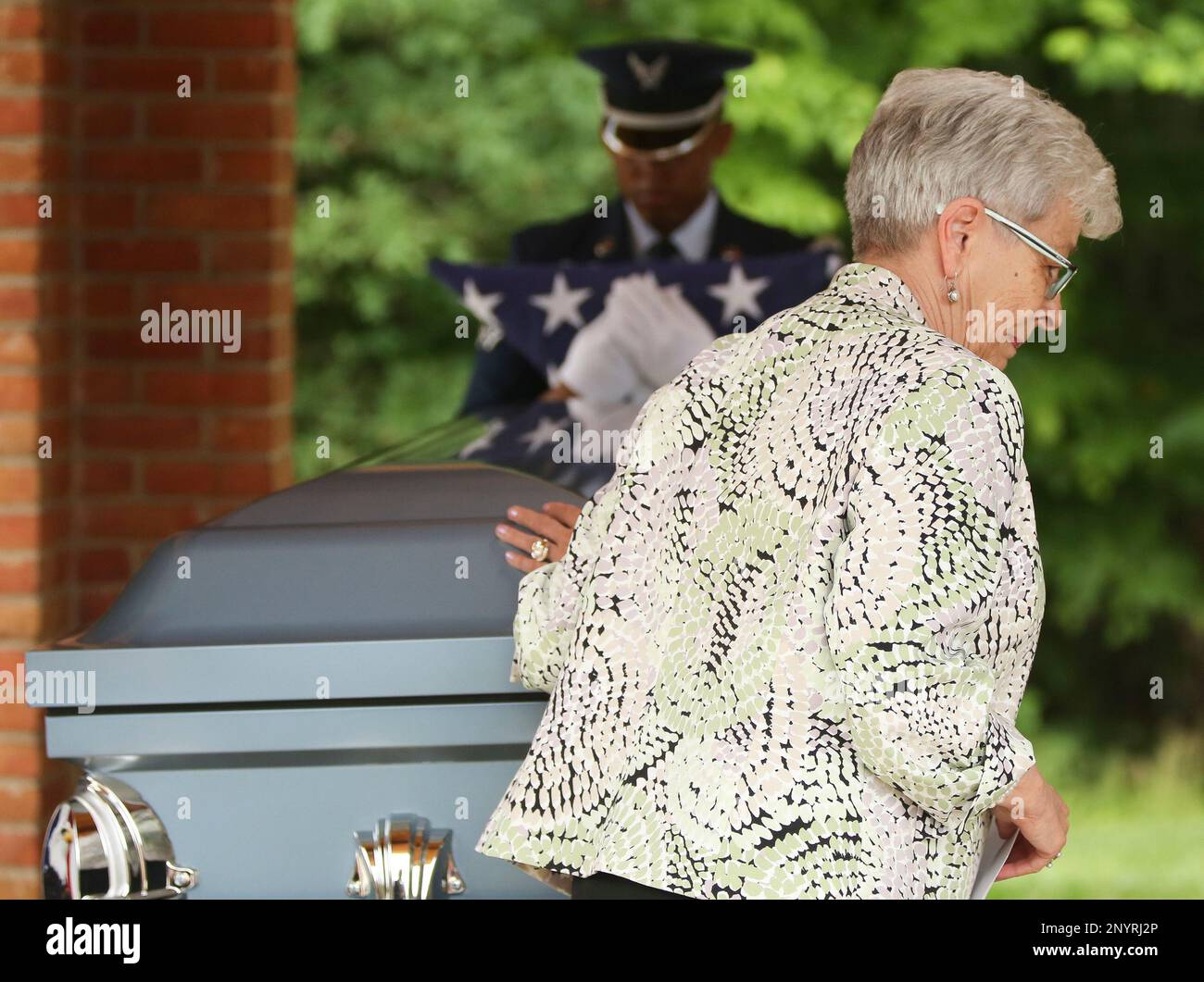 Judith Adair places her hand on her father's casket during the funeral ...