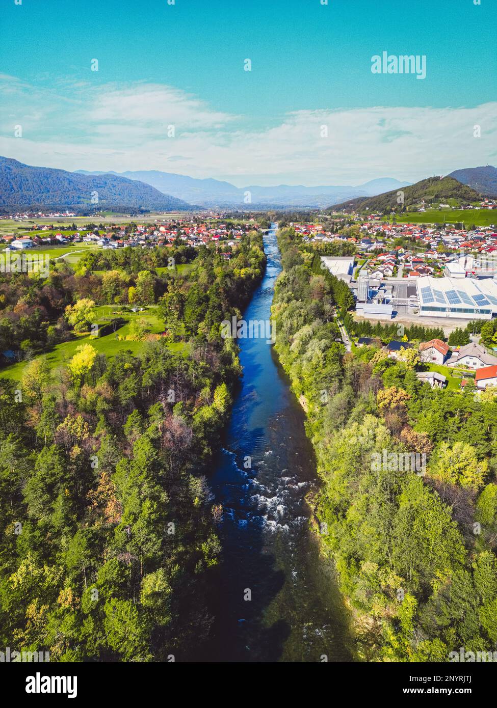 Vertical photo of a river running trough the suburbs on a sunny spring ...