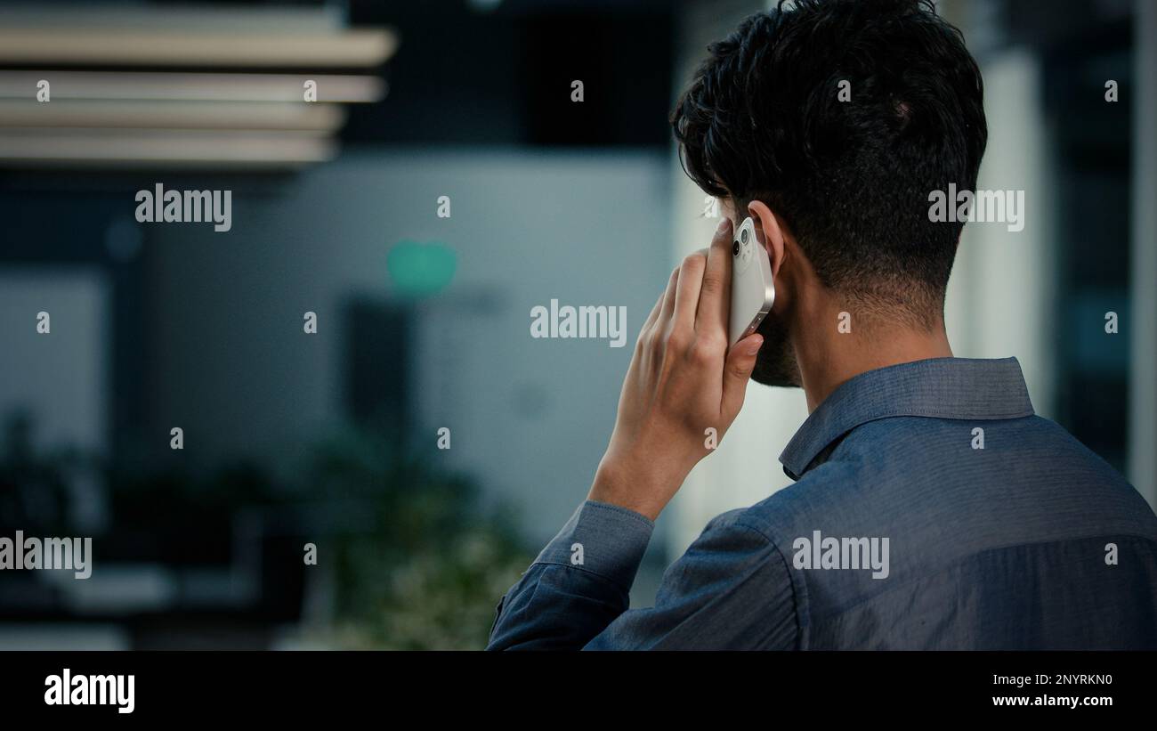 Back rear view man talking phone indoors unknown adult Indian ...