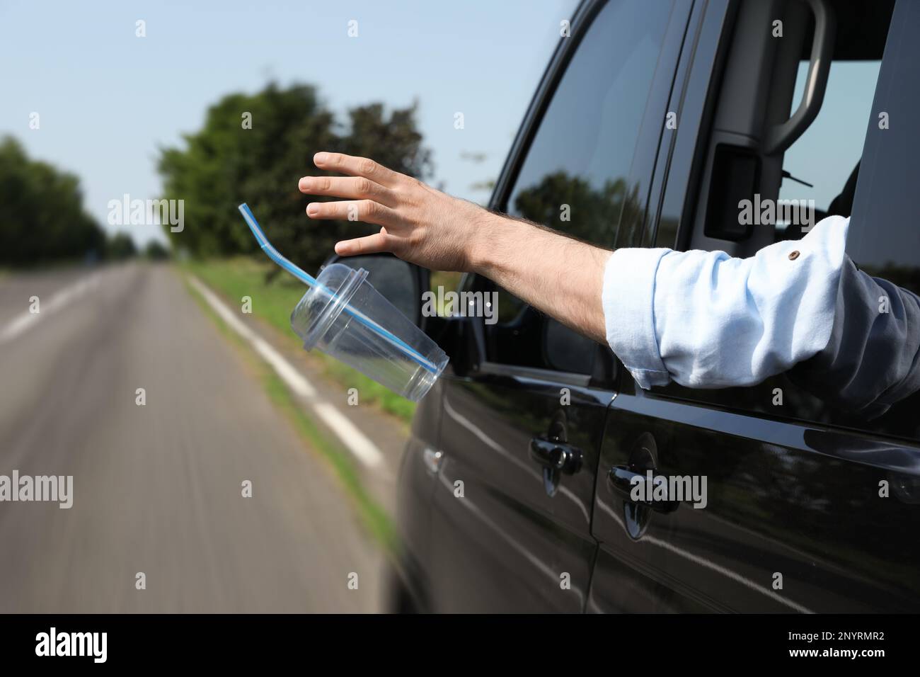 Driver throwing away plastic cup from car window. Garbage on road Stock ...