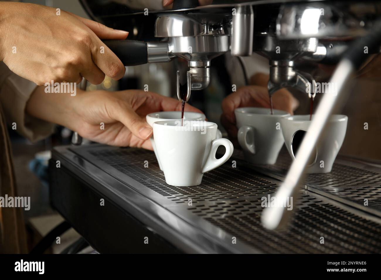 Barista making espresso using professional coffee machine, closeup ...
