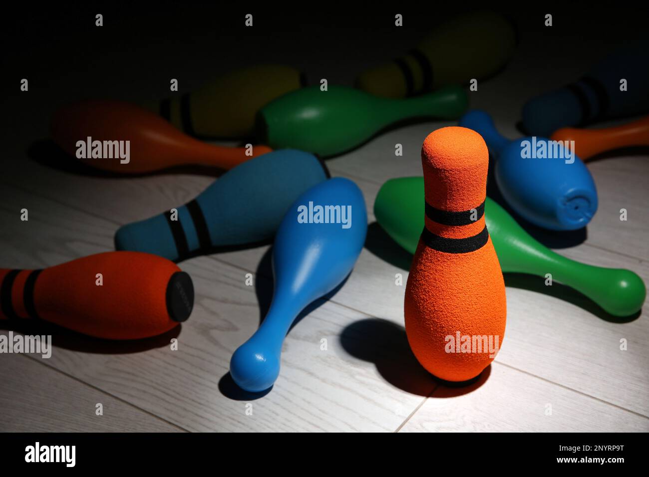 Bowling pin among fallen ones on wooden floor. Diversity concept Stock ...