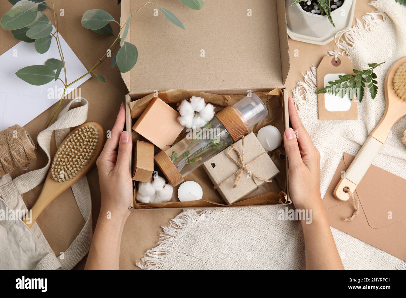 Woman with eco friendly personal care products at brown table, top view ...