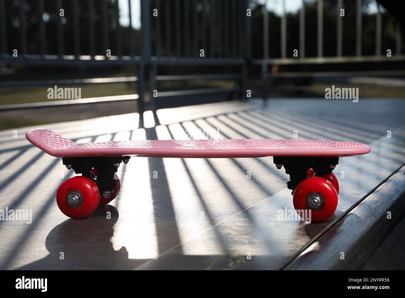 Modern pink skateboard with red wheels on top of ramp outdoors Stock ...