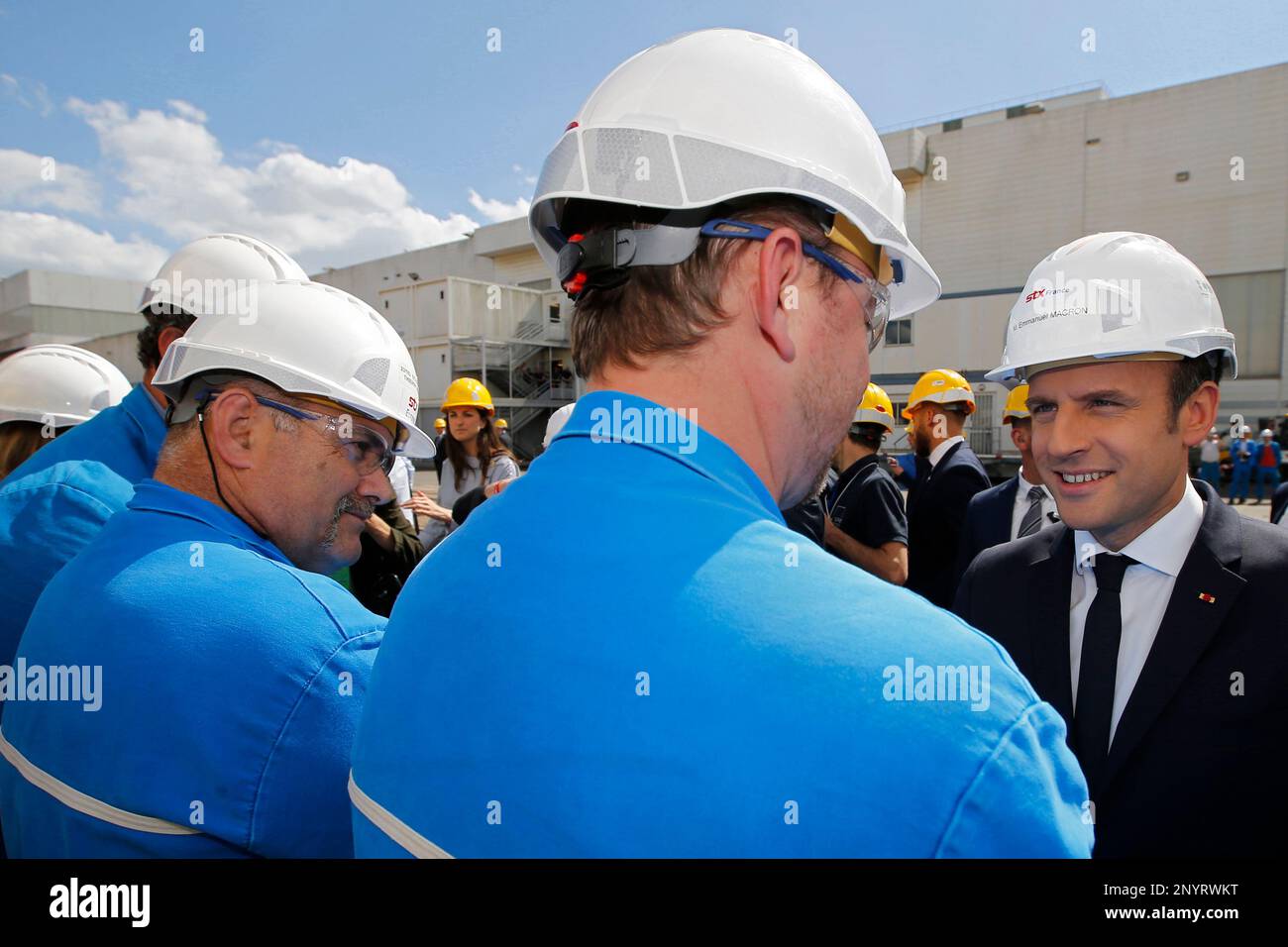 French President Emmanuel Macron, right, speaks to employees during a ...