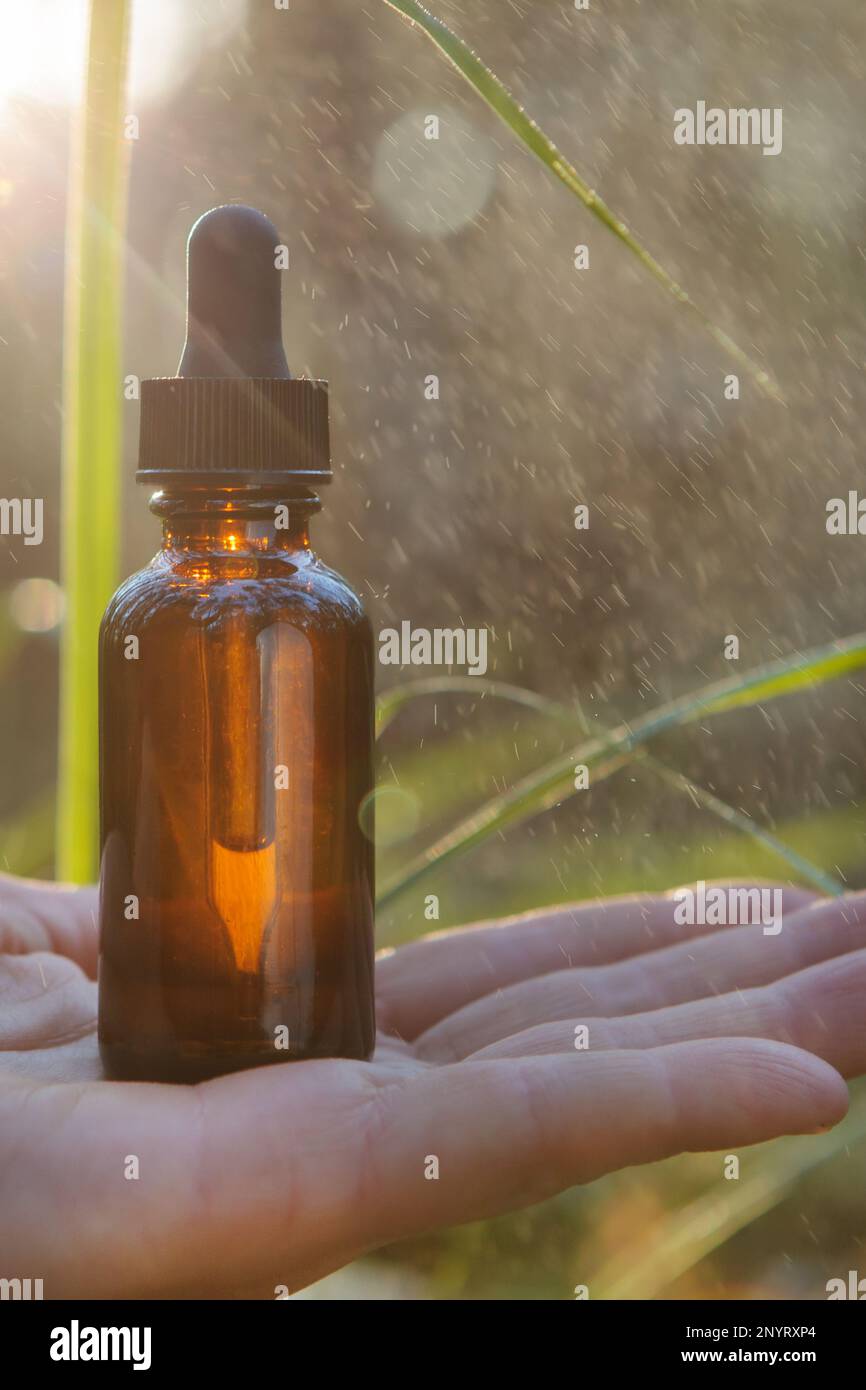 Dropper bottle held in your hand alternative herbal medicine supplement ...