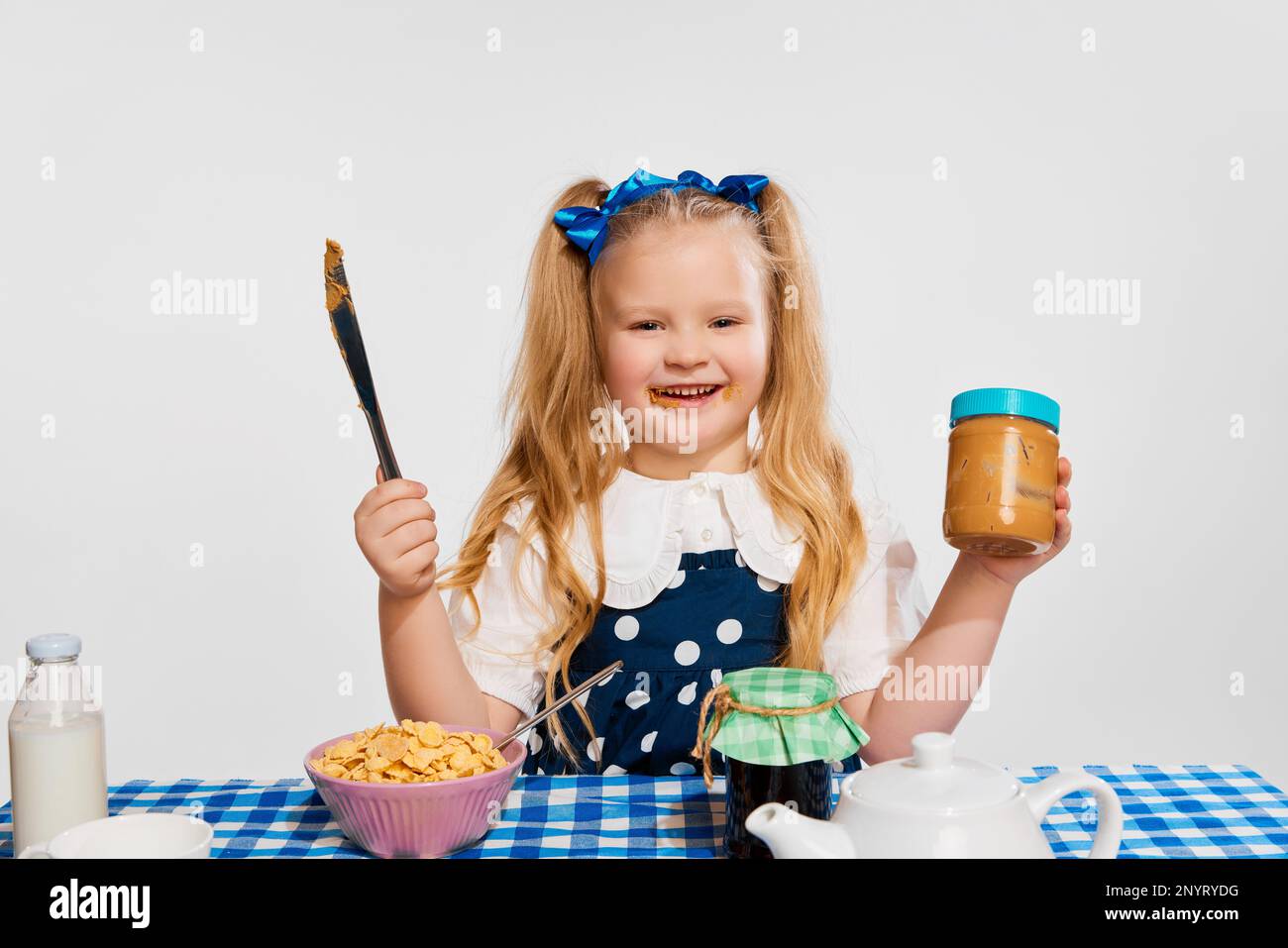 Happy smiling little girl, kid eating, having delicious breakfast ...
