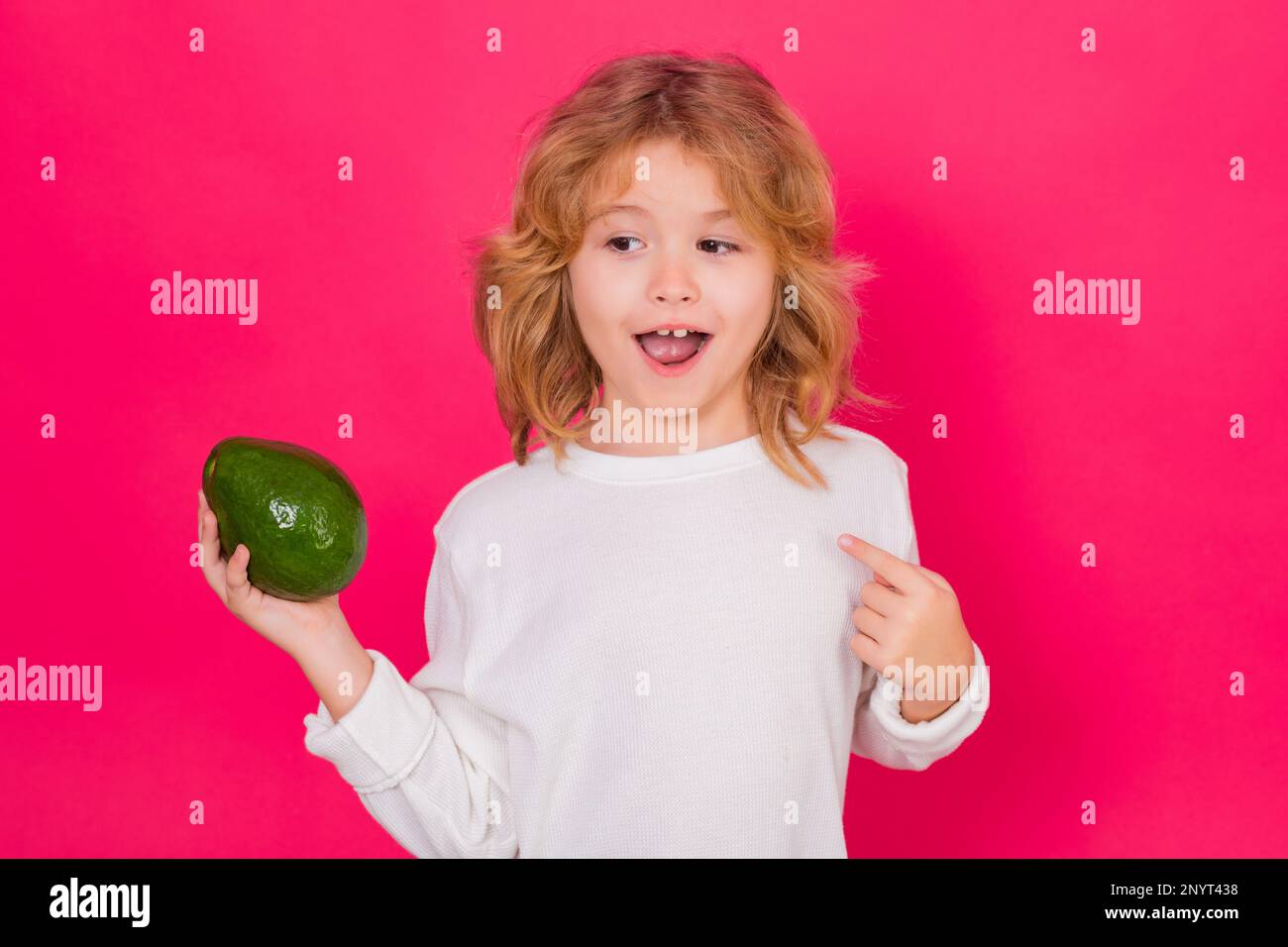 Kid hold red avocado in studio. Studio portrait of cute child with ...