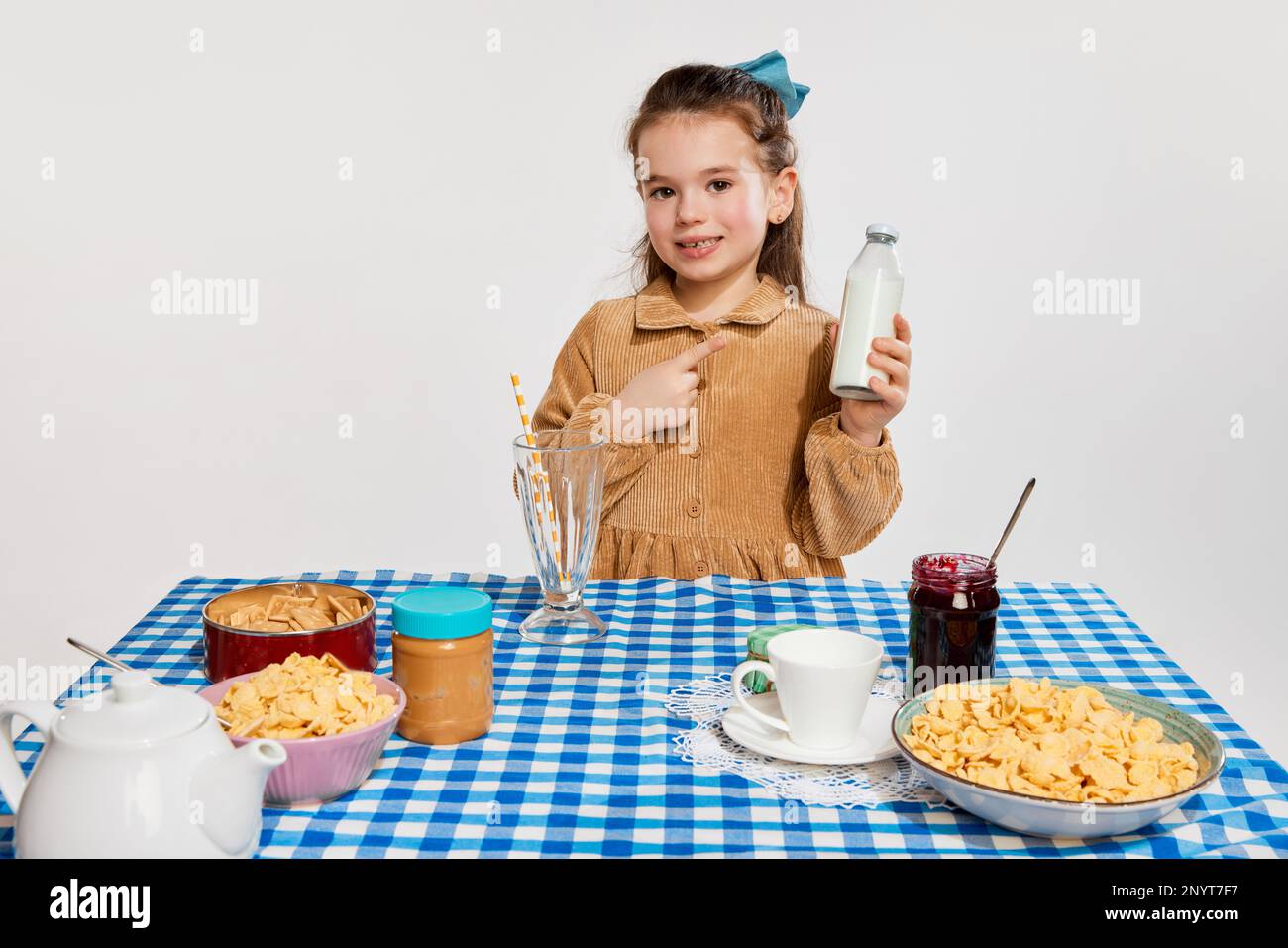 Cute beautiful little girl having yummy breakfast with cereal, posing ...