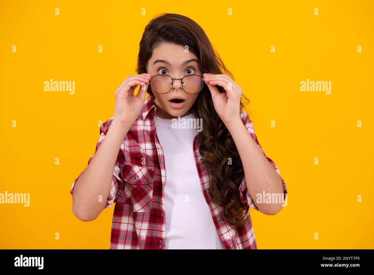 Cute school girl wearing glasses on yellow studio background, smart ...