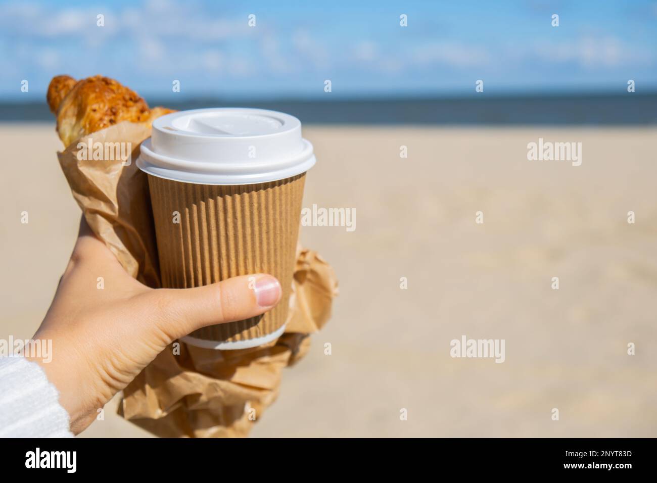 Tasty fresh croissants with coffee in paper cup in female hands on ...
