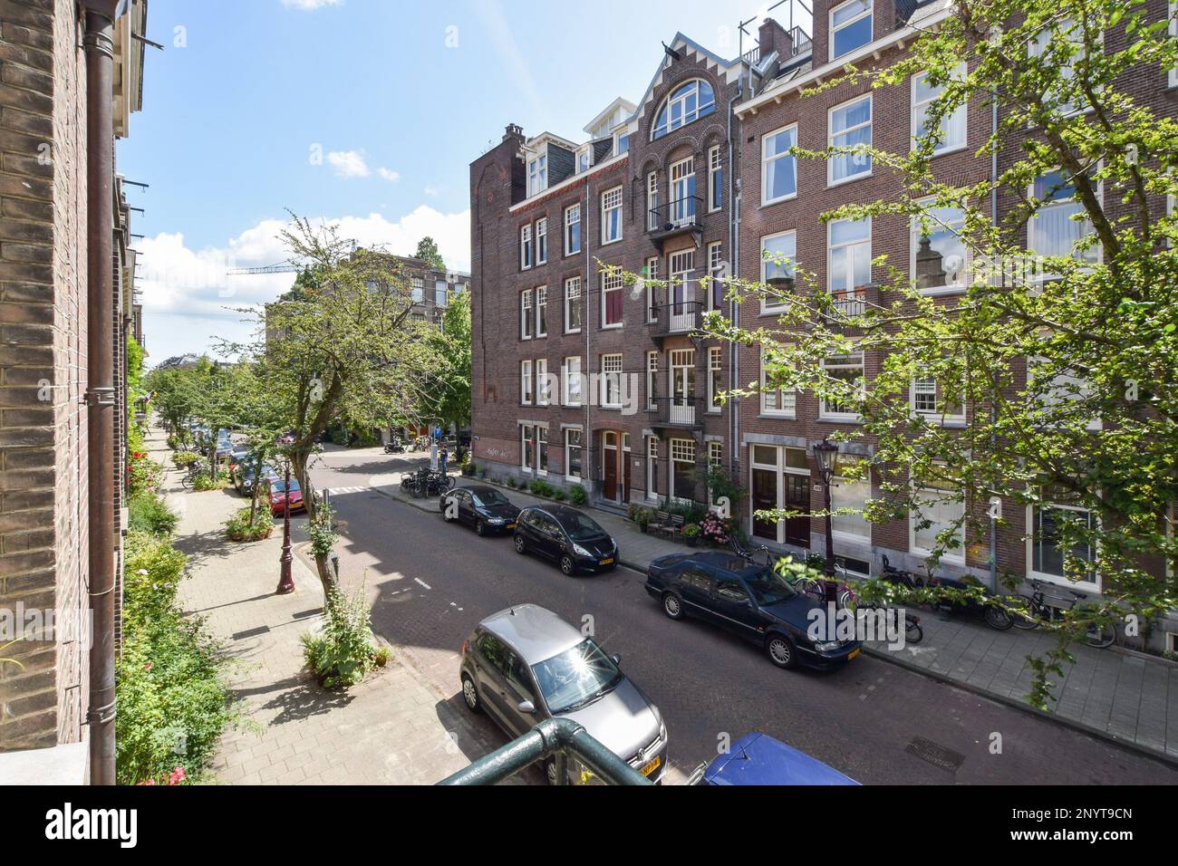 a city street with cars parked on the side and buildings in the back ...