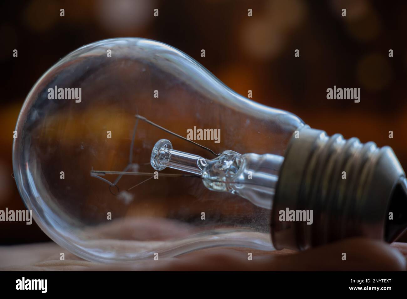 old incandescent light bulb in hand on blurry dark background Stock ...