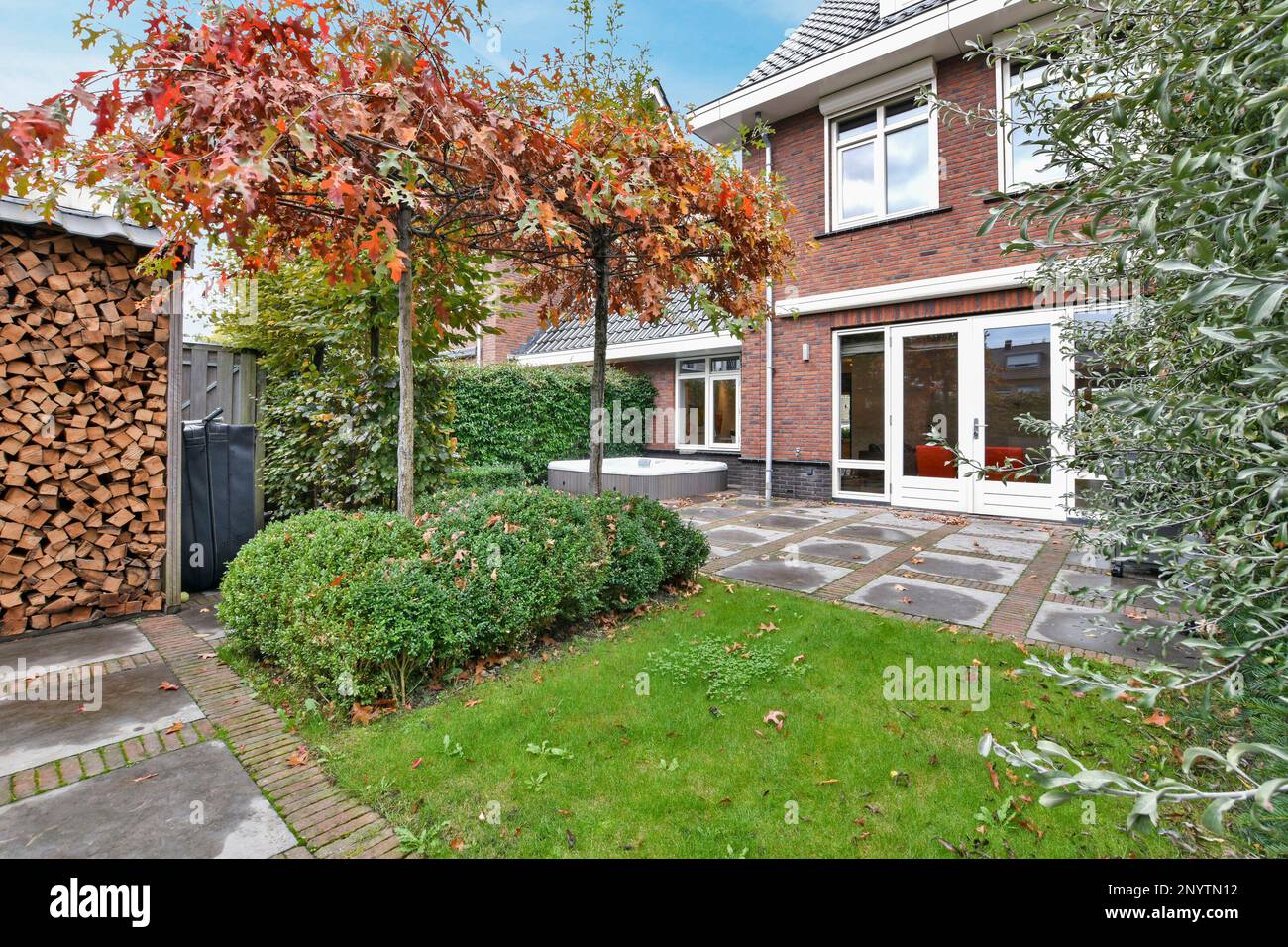 a house in the netherlands, with trees and bushes surrounding it's ...