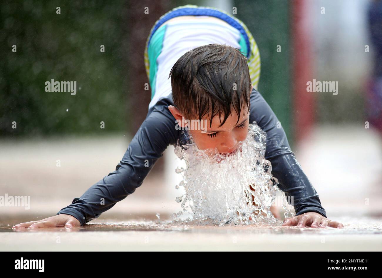 Hunter Hensley, 4, of Safety Harbor, dunks his face into a water jet ...
