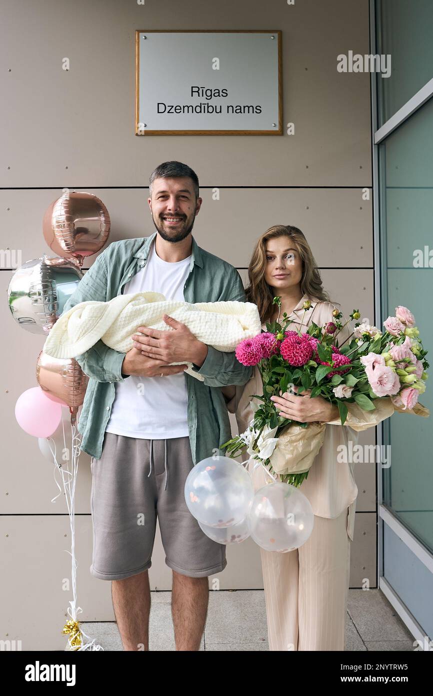 Happy caucasian couple with newborn baby. Father holds baby and mother ...