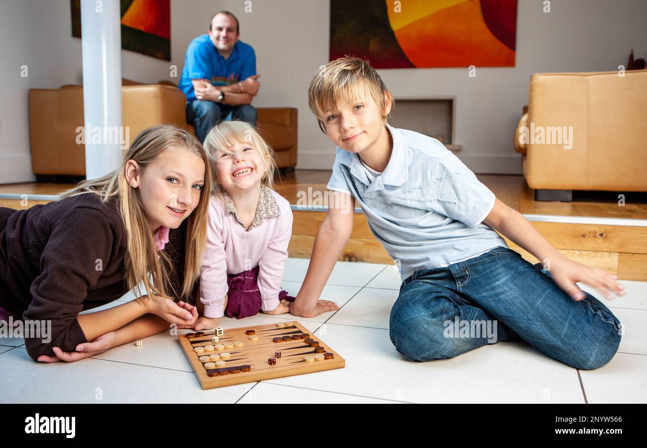 Family Life, Backgammon. A relaxed portrait of a group of siblings ...